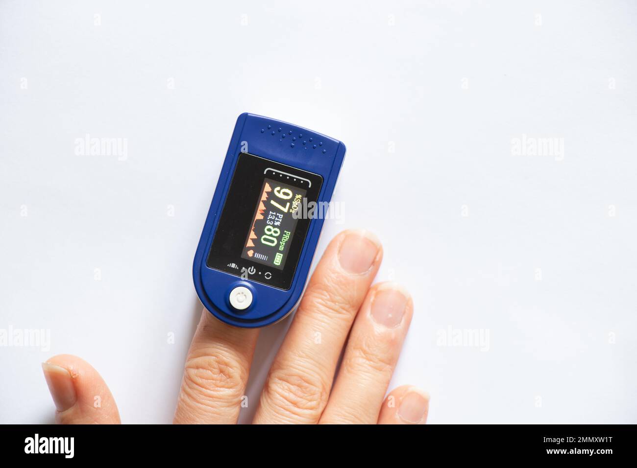 pulse oximeter on the finger of a woman on an isolated background ...