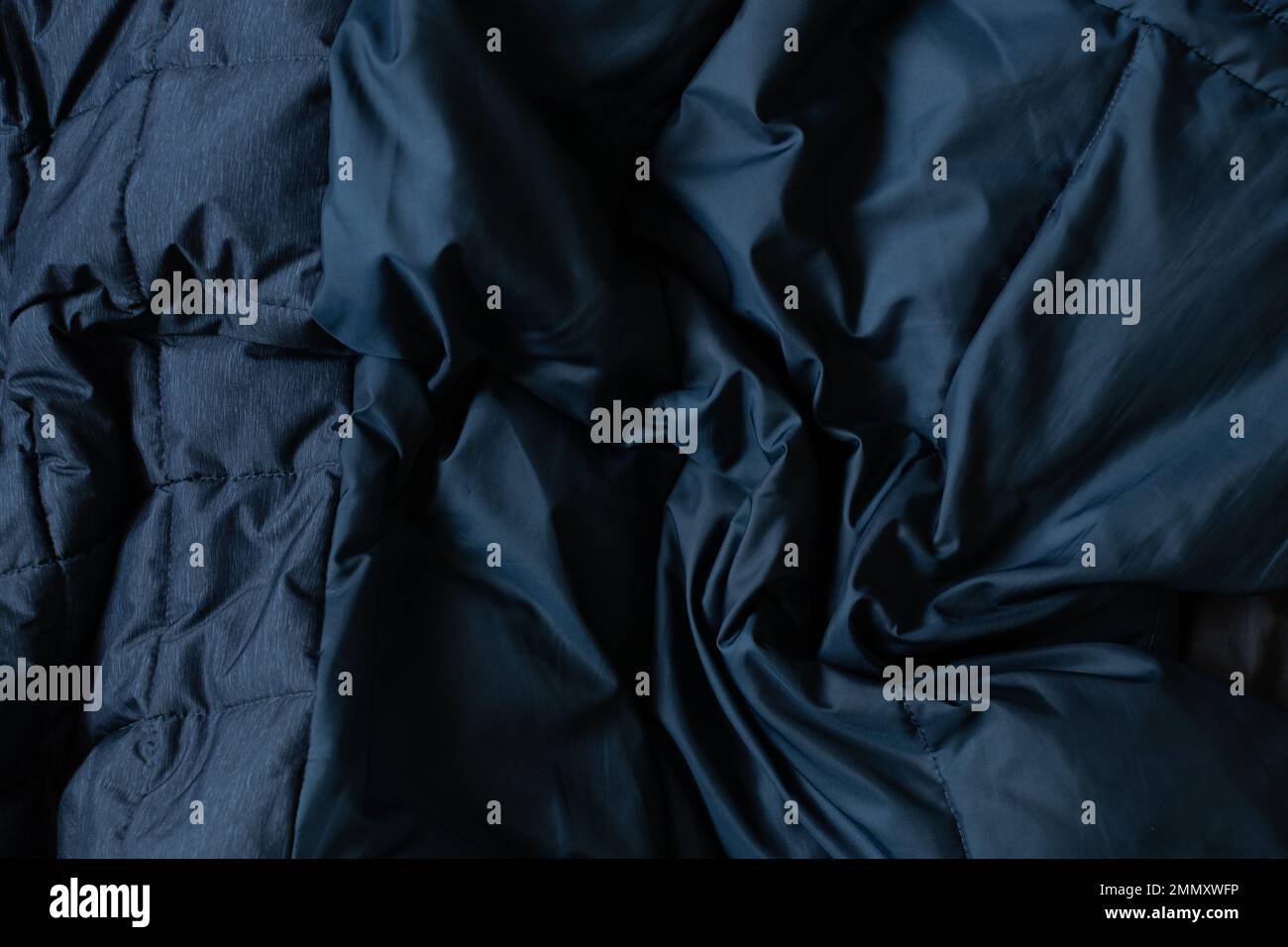 dark blue background of a blown winter jacket, fabric wrinkled as a ...