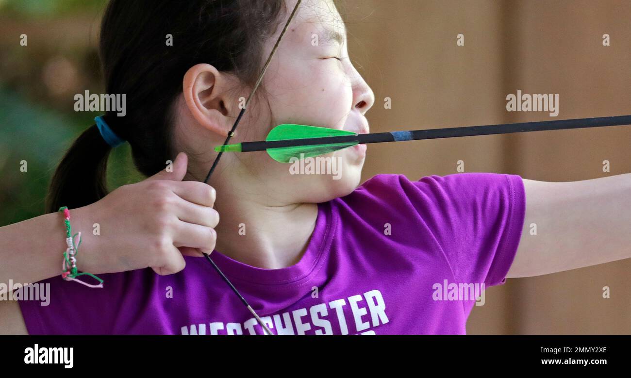 Girl Scout Lily Pogue takes aim during an archery session at a Girl ...