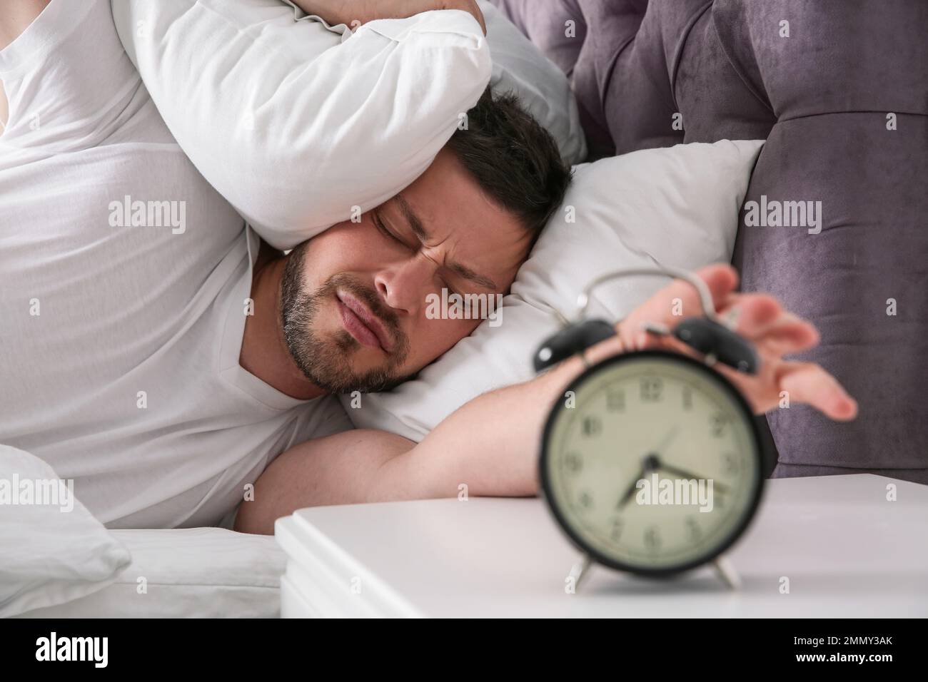 Male turning off alarm clock hi-res stock photography and images - Alamy
