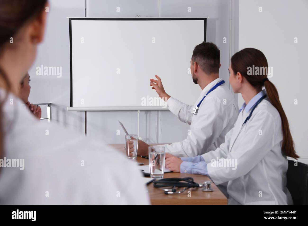 Team of doctors looking at projection screen indoors Stock Photo - Alamy