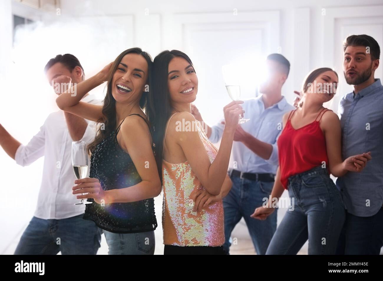 Couple of happy friends with champagne dancing at party Stock Photo - Alamy