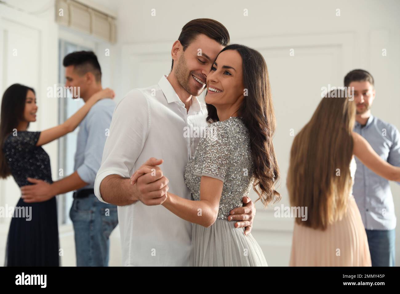 Lovely young couple dancing together at party Stock Photo - Alamy