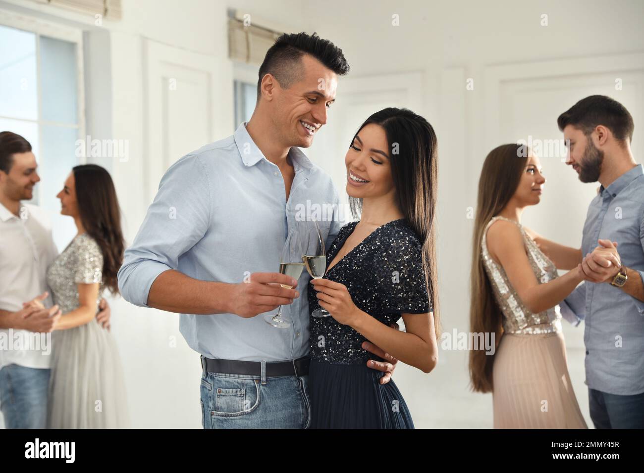 Lovely young couple with glasses of champagne at dancing party Stock ...