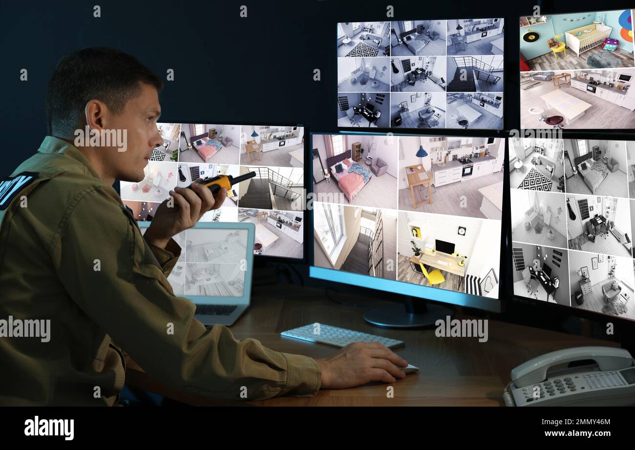 Security guard with portable transmitter monitoring modern CCTV cameras ...