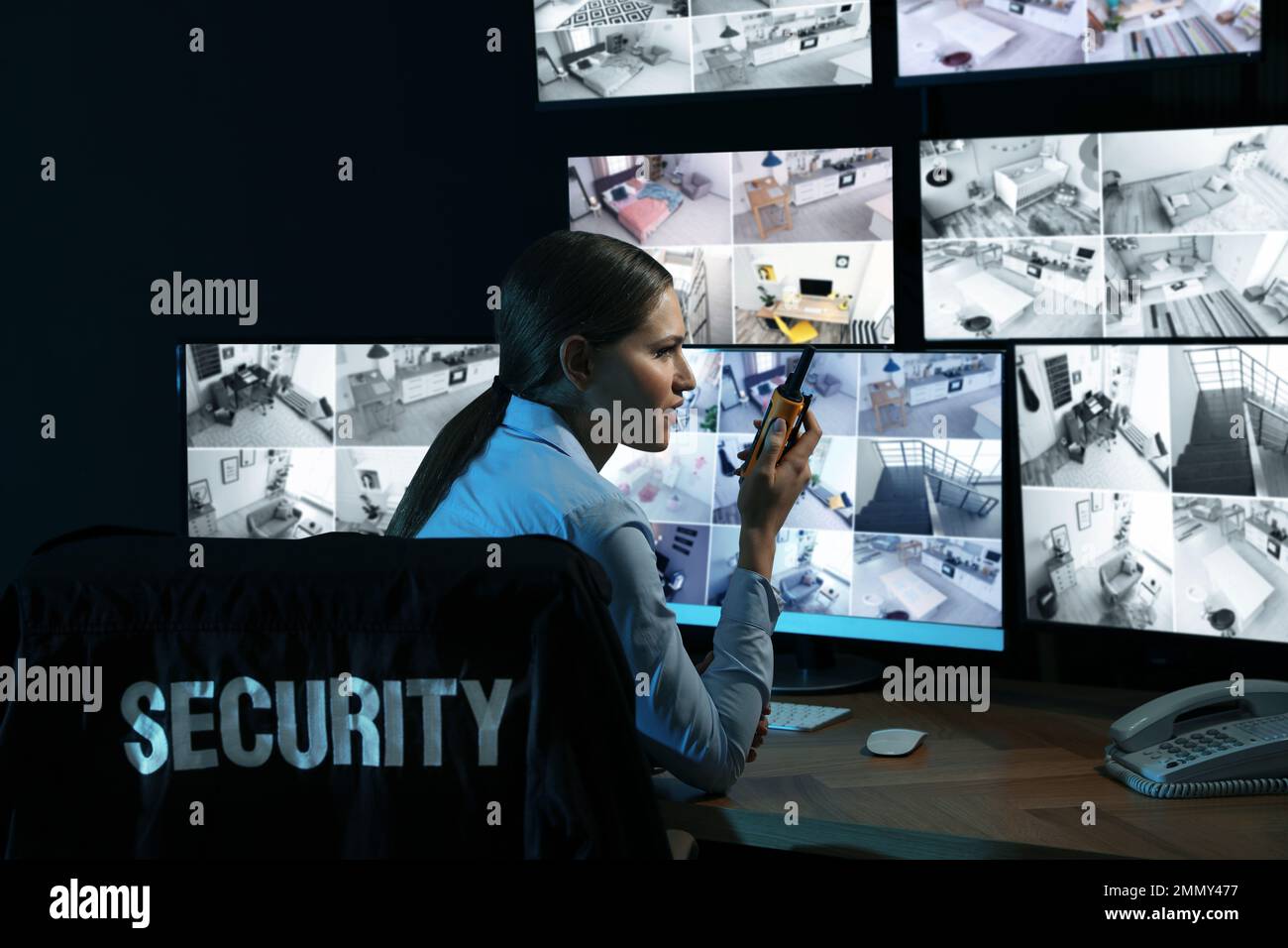 Security guard with portable transmitter monitoring modern CCTV cameras ...