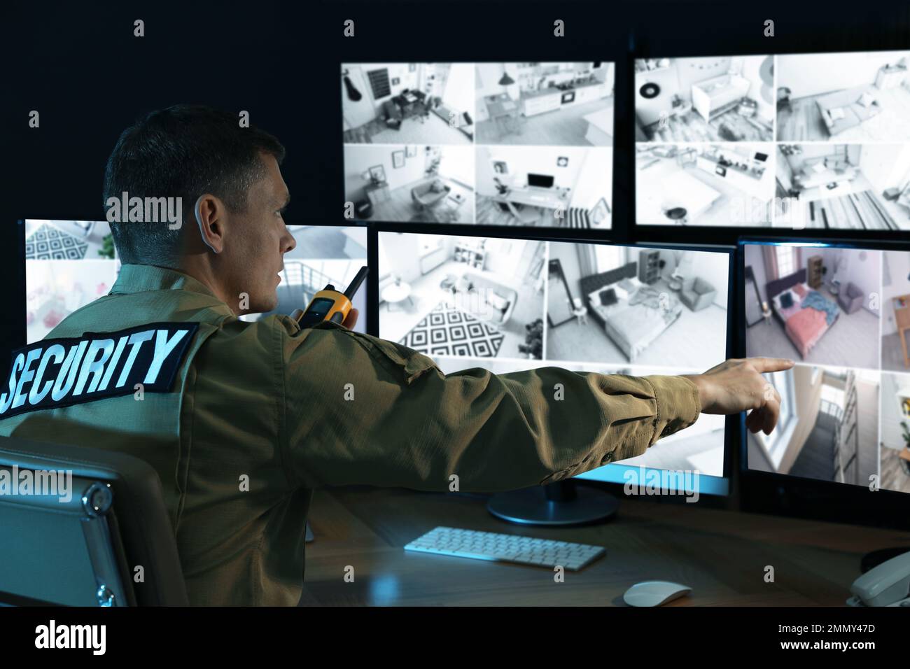 Security guard with portable transmitter monitoring modern CCTV cameras ...