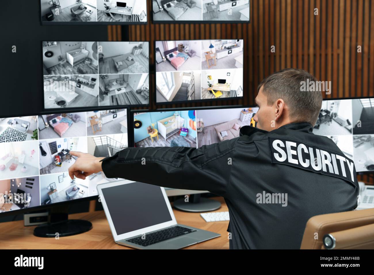 Security guard with portable transmitter monitoring modern CCTV cameras ...