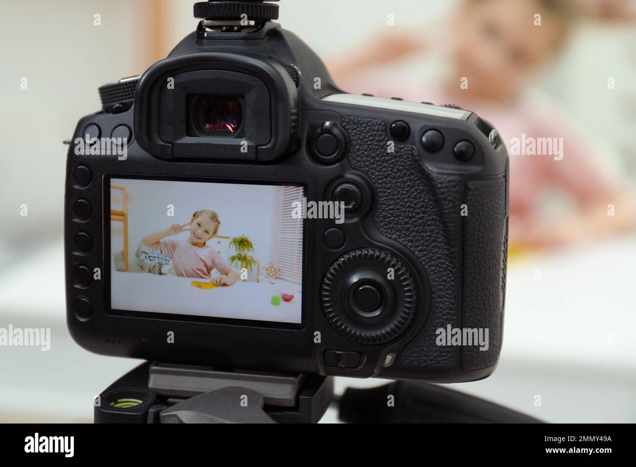 Cute little blogger with slime recording video at home, focus on camera ...