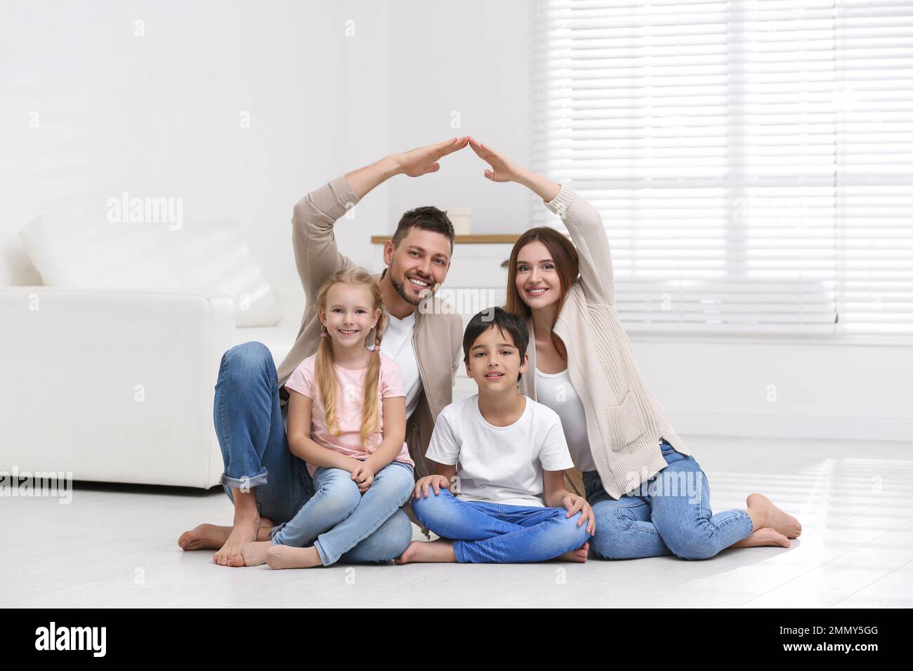 Happy family forming house roof with their hands at home. Insurance ...