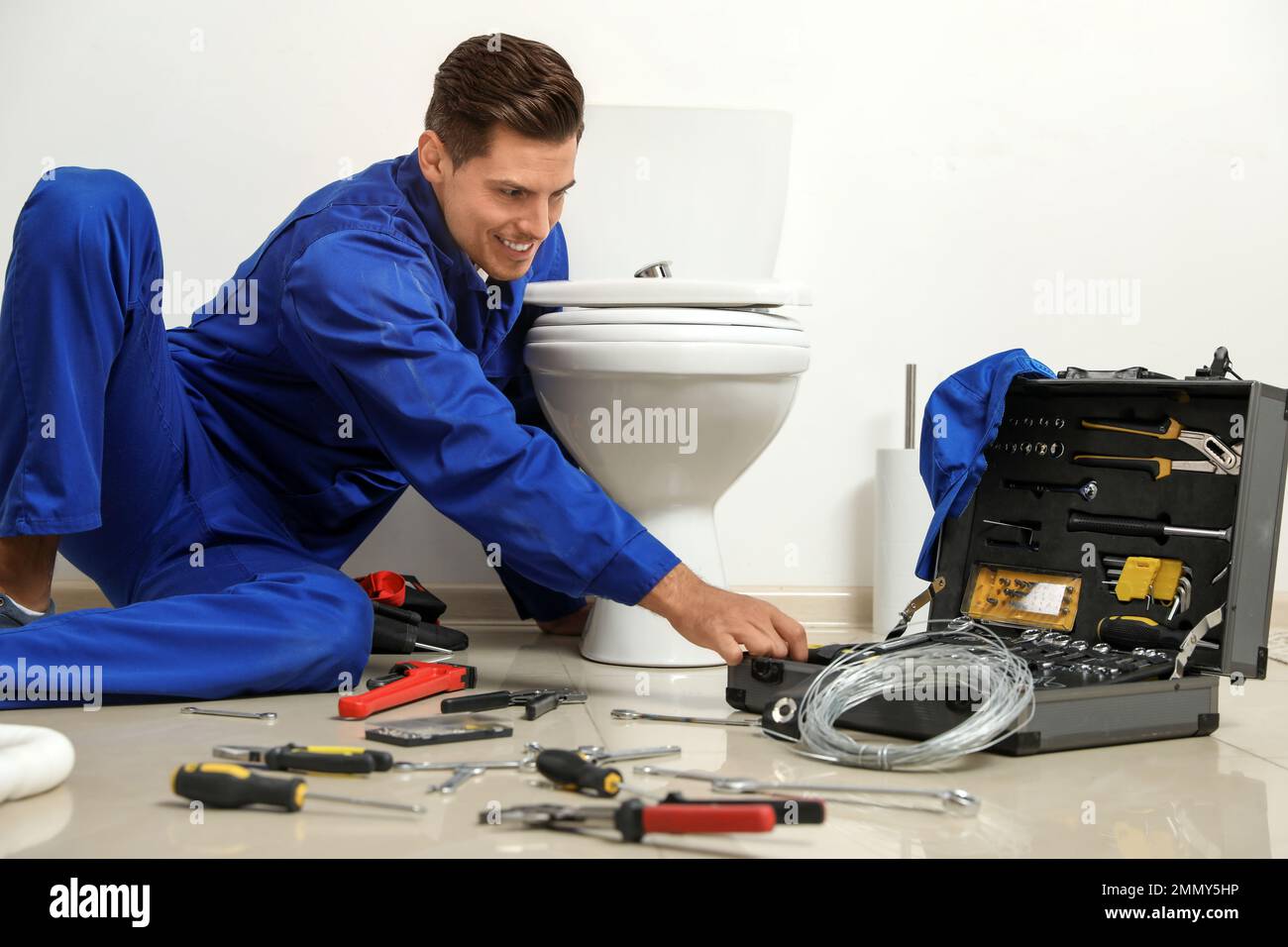 Professional plumber working with toilet bowl in bathroom Stock Photo ...