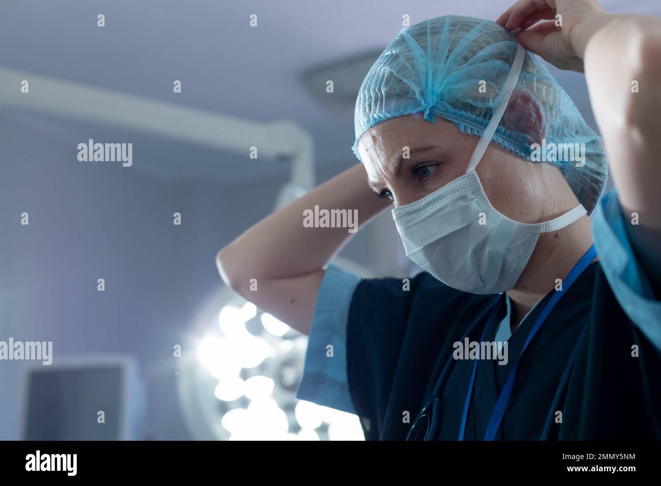 Caucasian female surgeon in an operating theatre, wearing face mask ...
