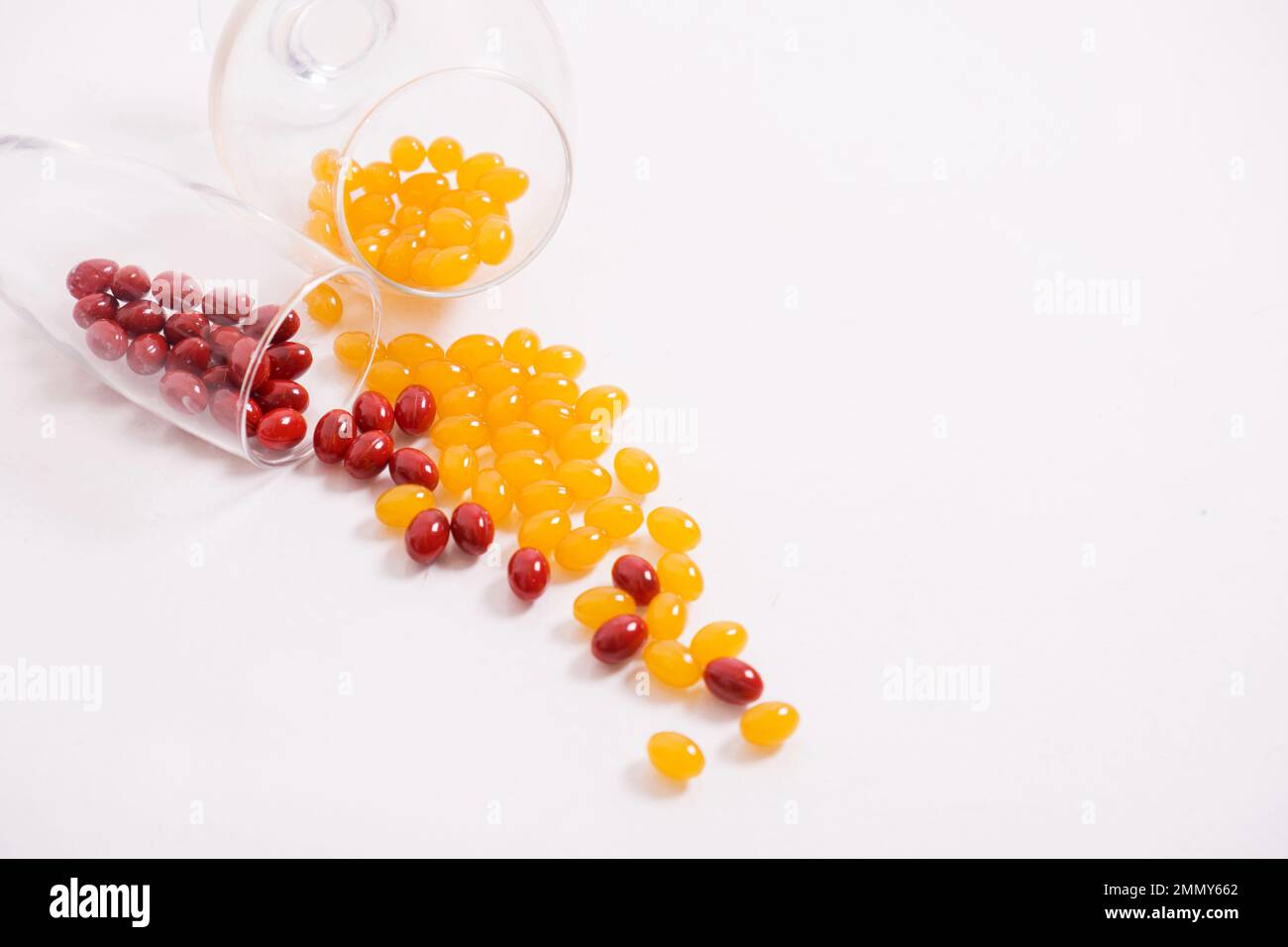Tablets, capsules for vision. Red and yellow vitamins are poured onto ...