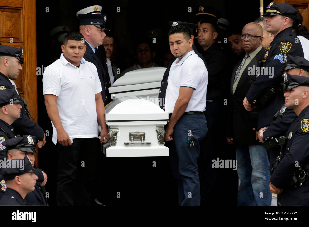Five caskets are carried out of the church during a funeral for five ...