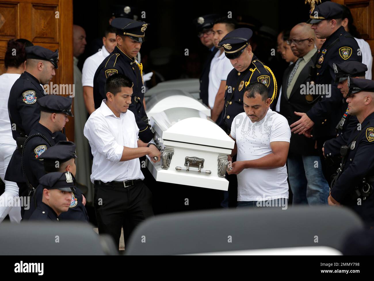 Five caskets are carried out of the church during a funeral for five ...