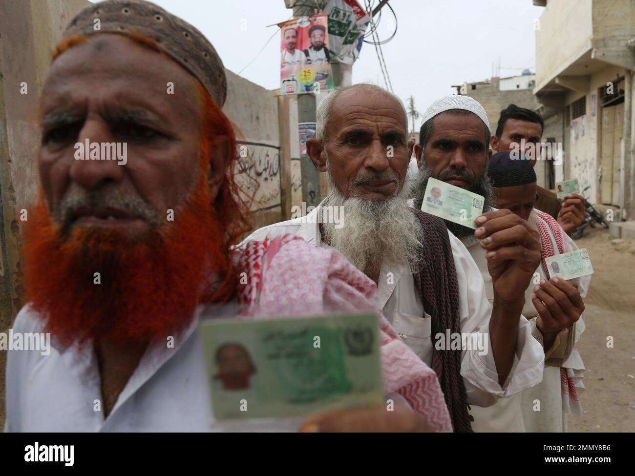 Pakistani voters pose to show their identity cards waiting to cast ...