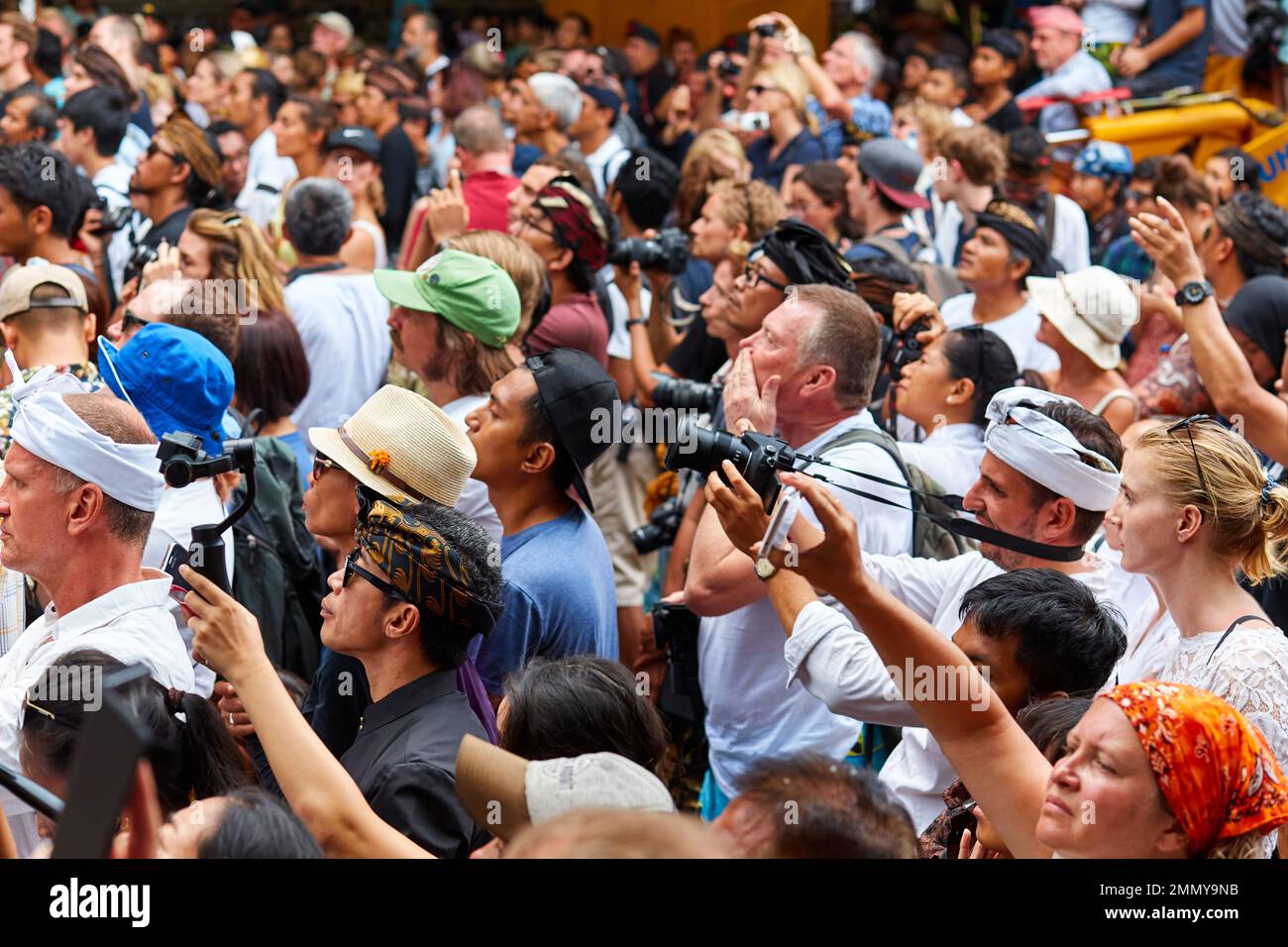 A crowd of people at a public event. People filming with cameras and ...