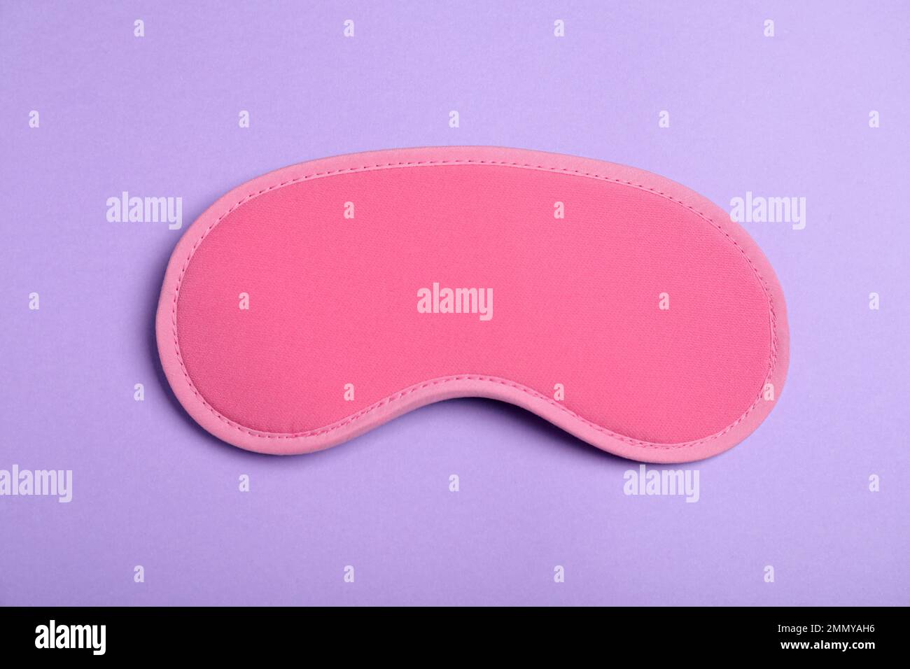 Pink sleeping mask on violet background, top view. Bedtime accessory ...