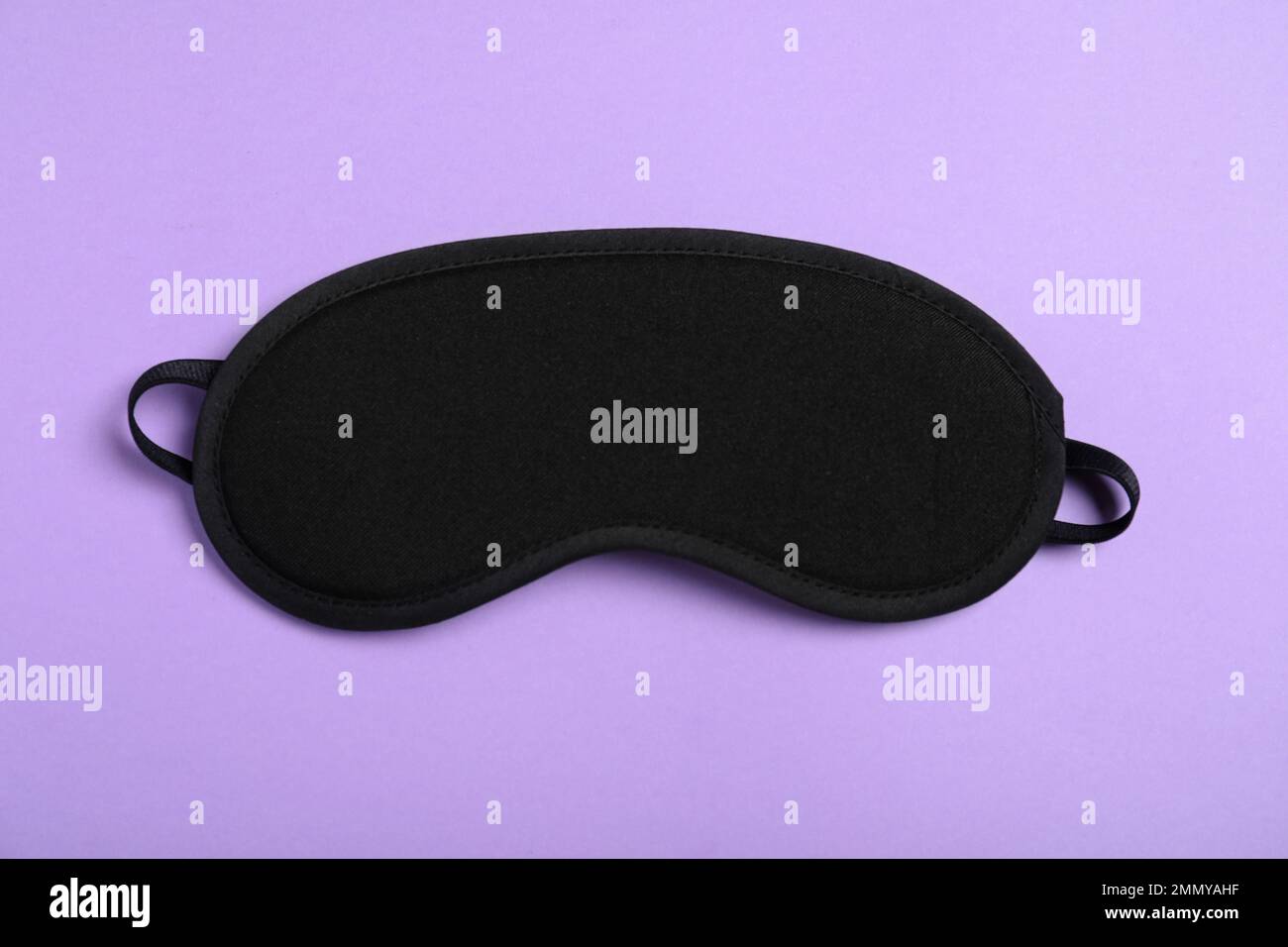 Black sleeping mask on violet background, top view. Bedtime accessory ...