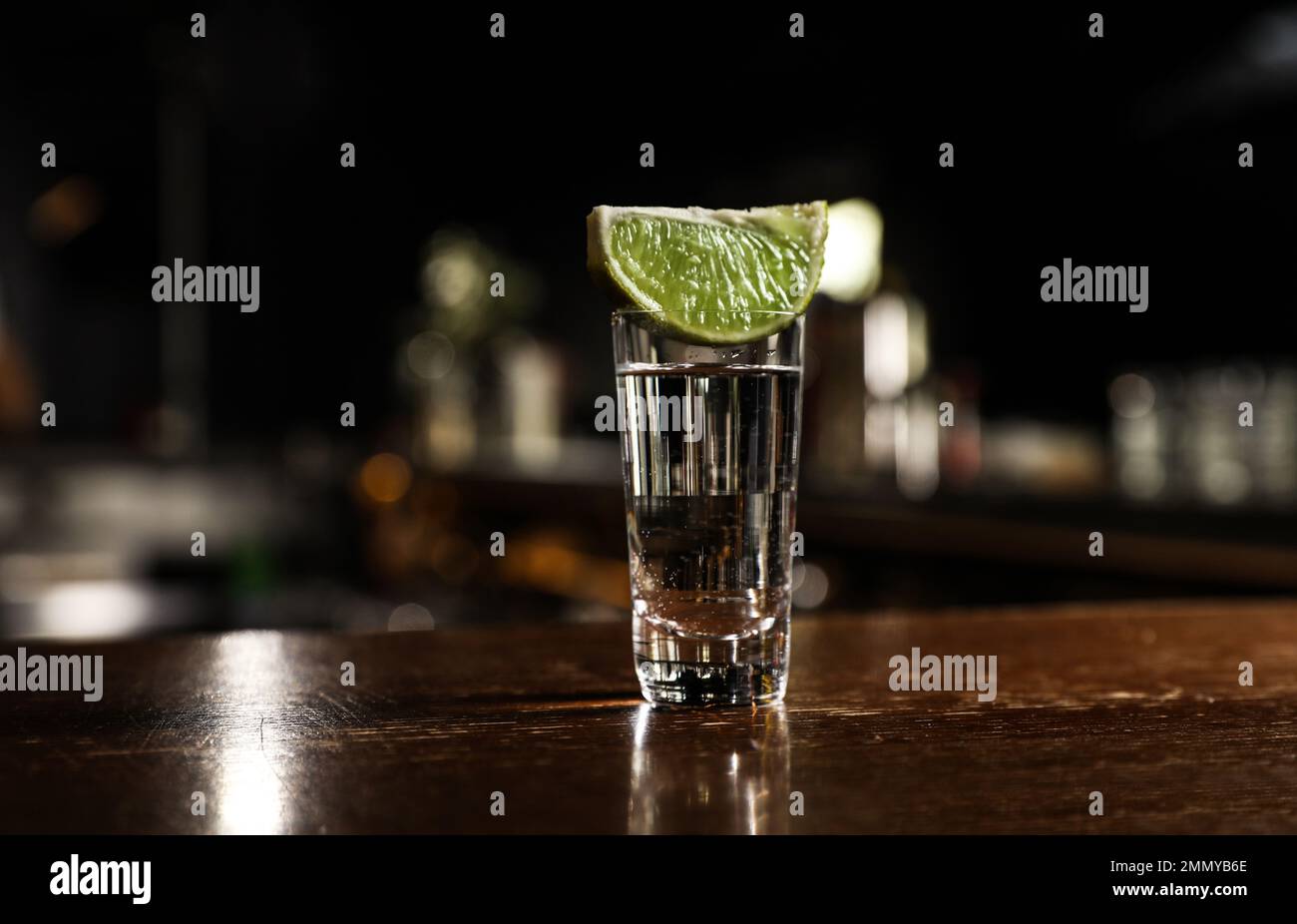 Mexican Tequila shot with lime slice on wooden bar counter Stock Photo ...