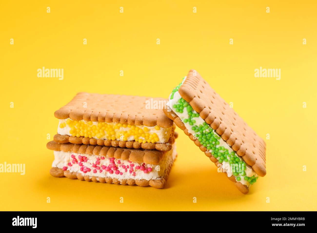 Sweet delicious ice cream cookie sandwiches on yellow background Stock ...
