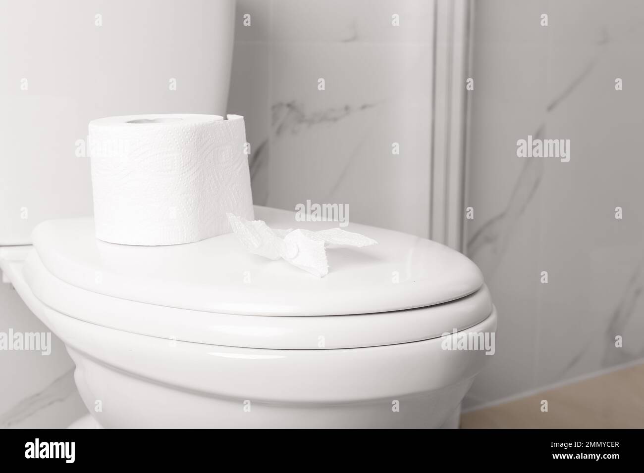 New paper roll on toilet bowl in bathroom Stock Photo - Alamy