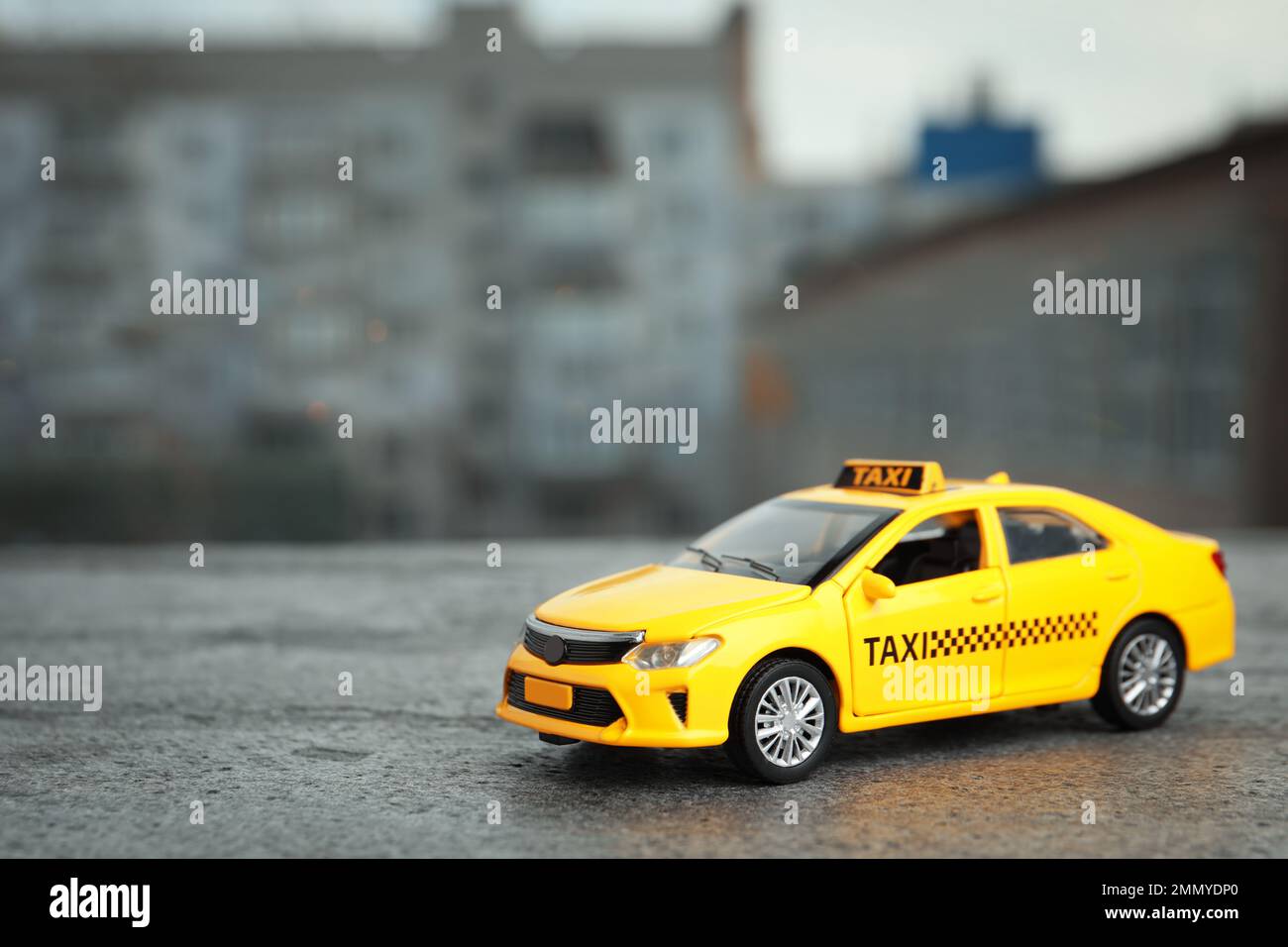 Yellow taxi car model on city street. Space for text Stock Photo - Alamy