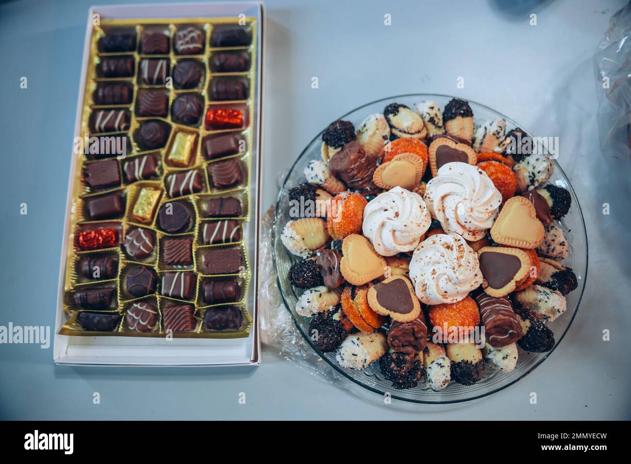 Box and plate with different candy and biscuits set out for guests on a ...