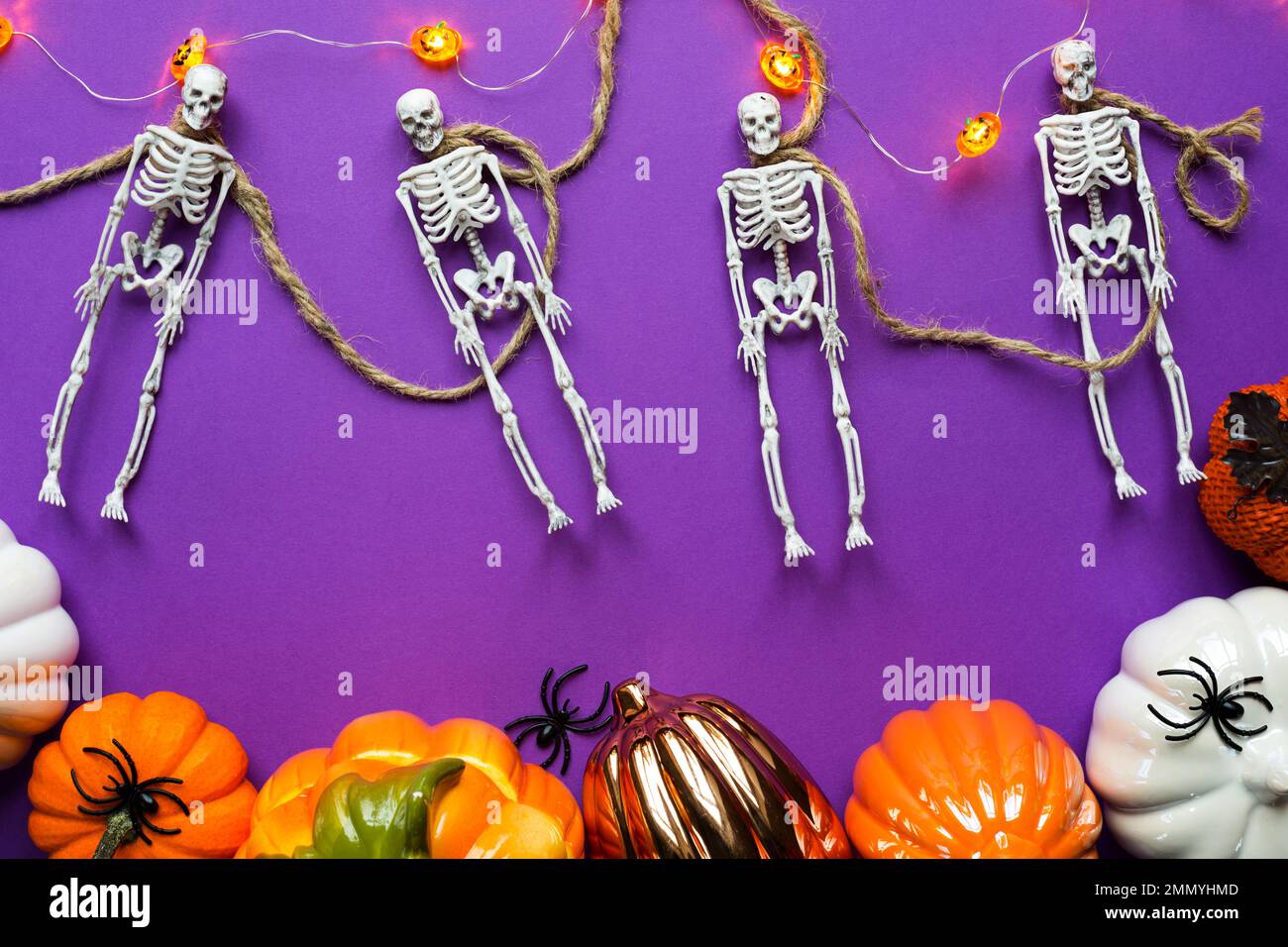 Halloween layout of garland of skeletons on a rope, glowing Jack o ...