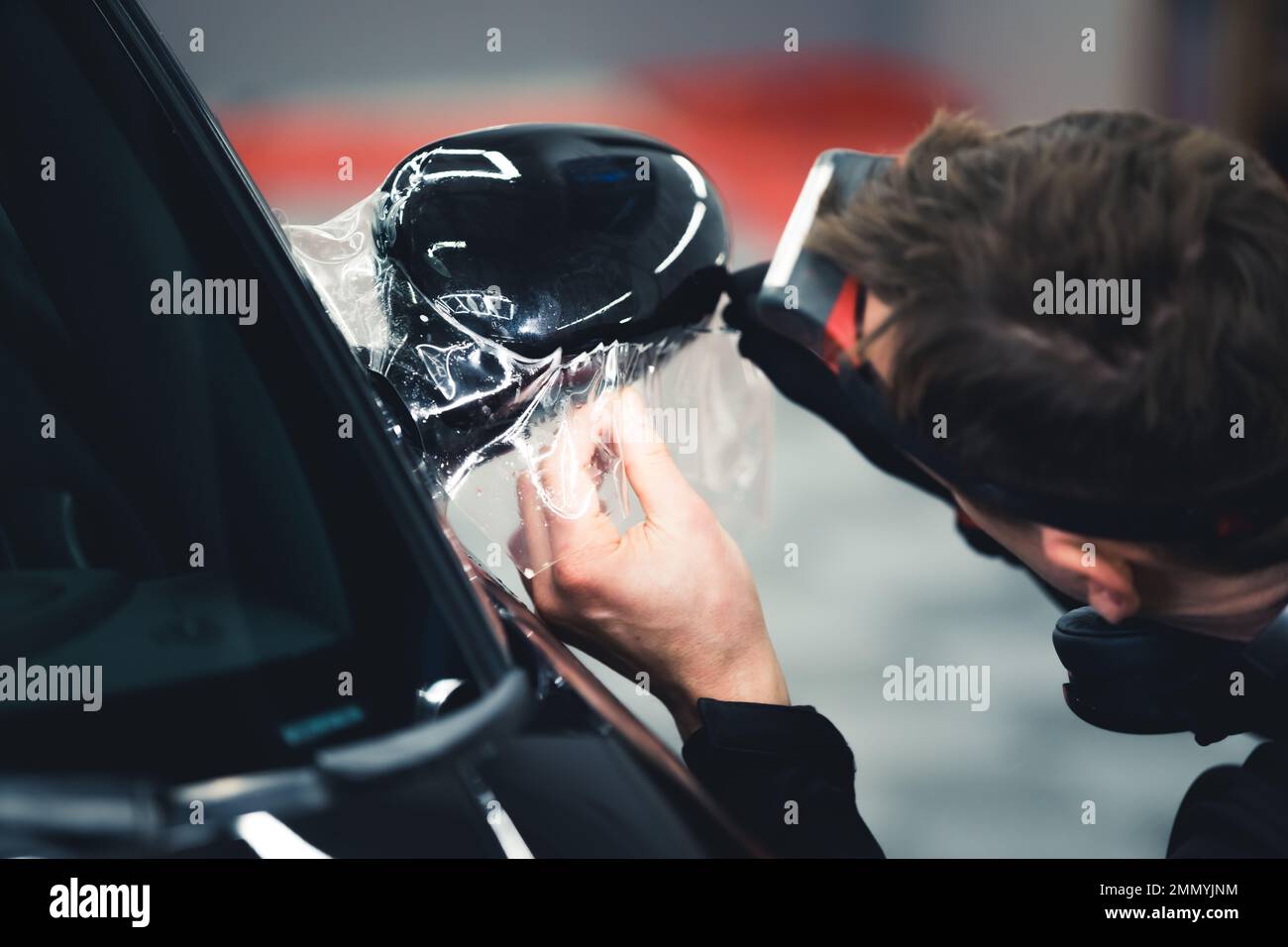 PPF wrapping process. Back view of unrecognizable professional mechanic ...