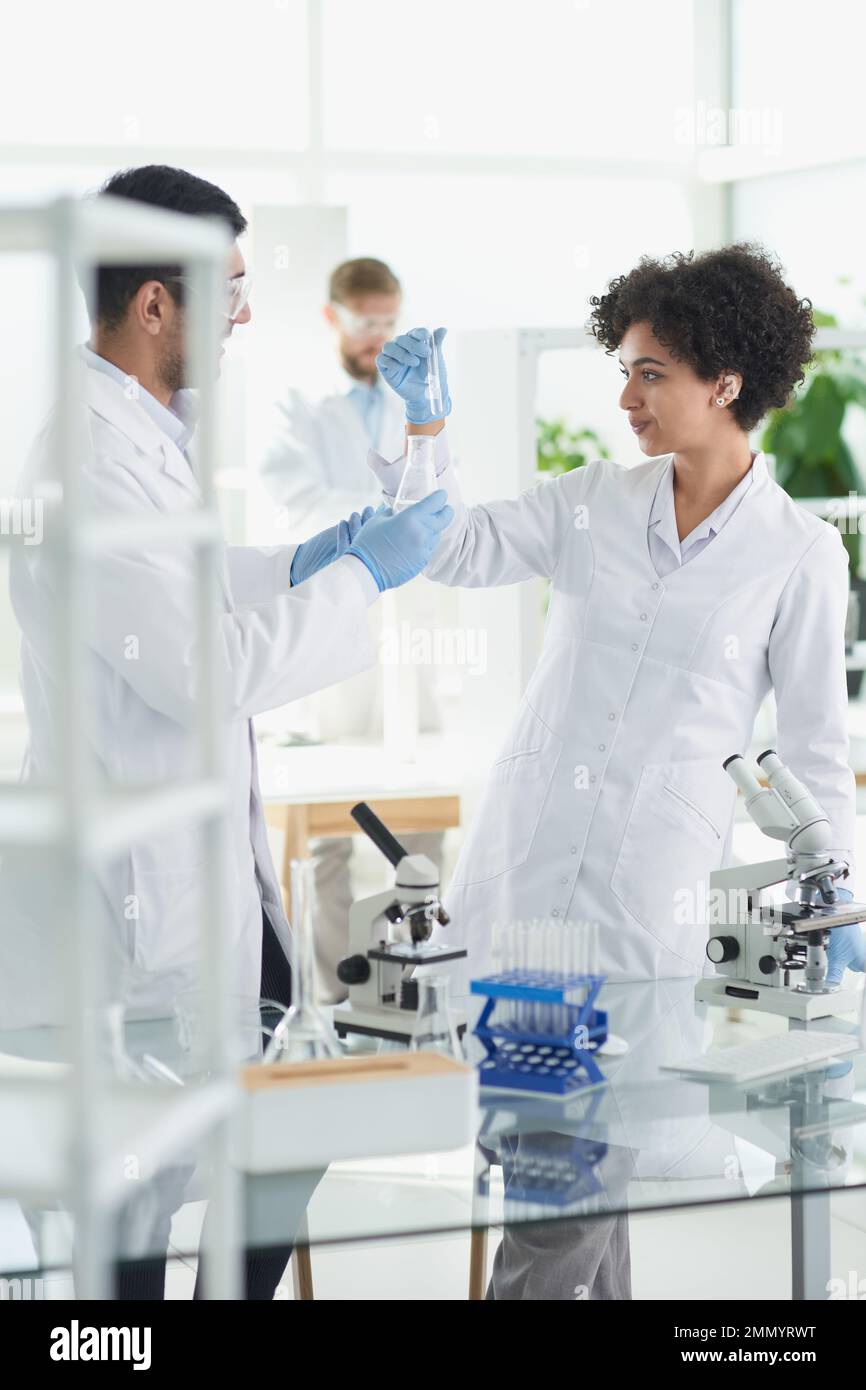 Team of Scientists Working Using Microscope, Analysing Microbiology ...