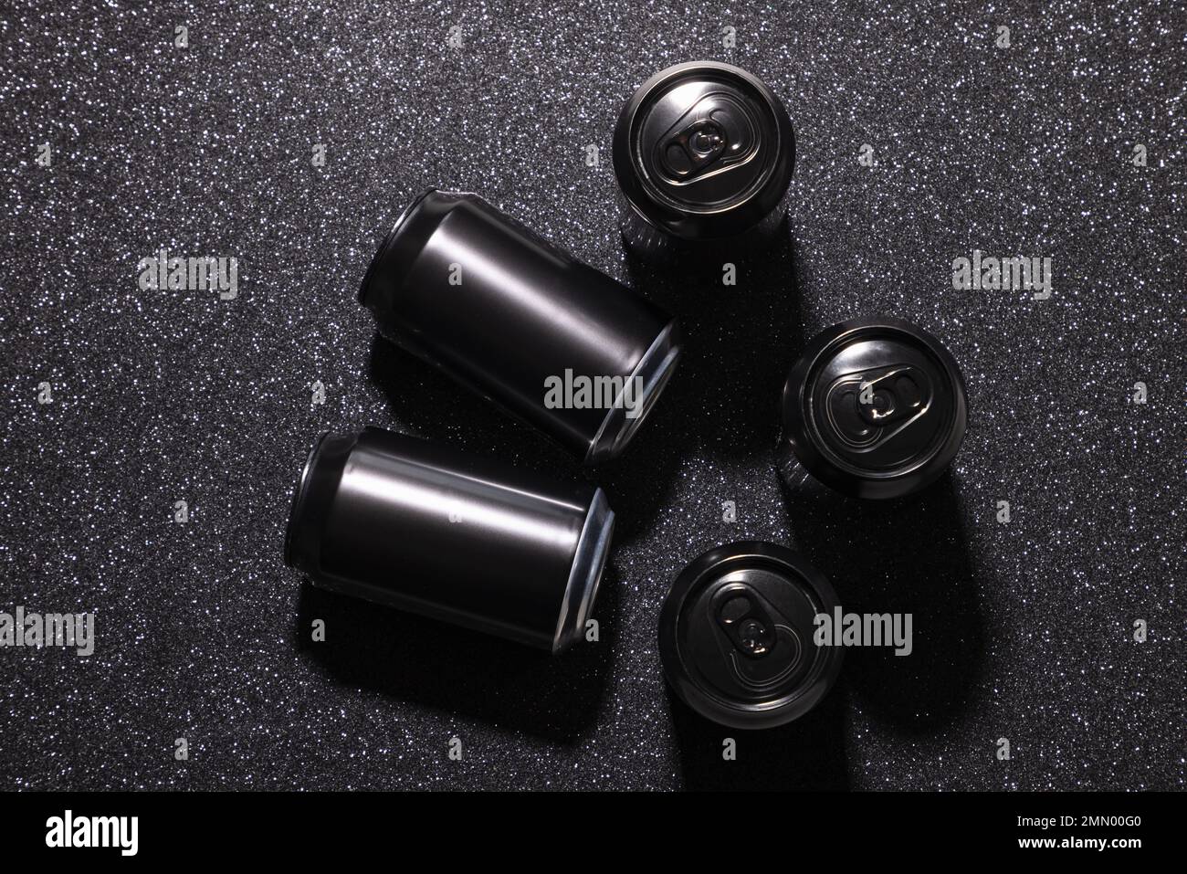 Five black beer cans on a black background with sparkles (selective ...