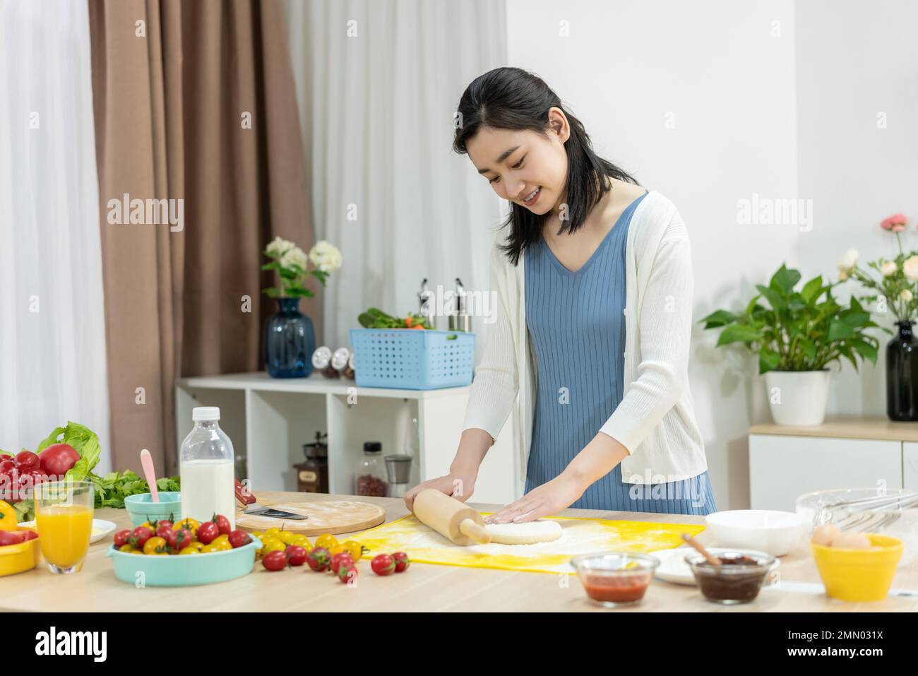 Happy woman making refreshments Stock Photo - Alamy