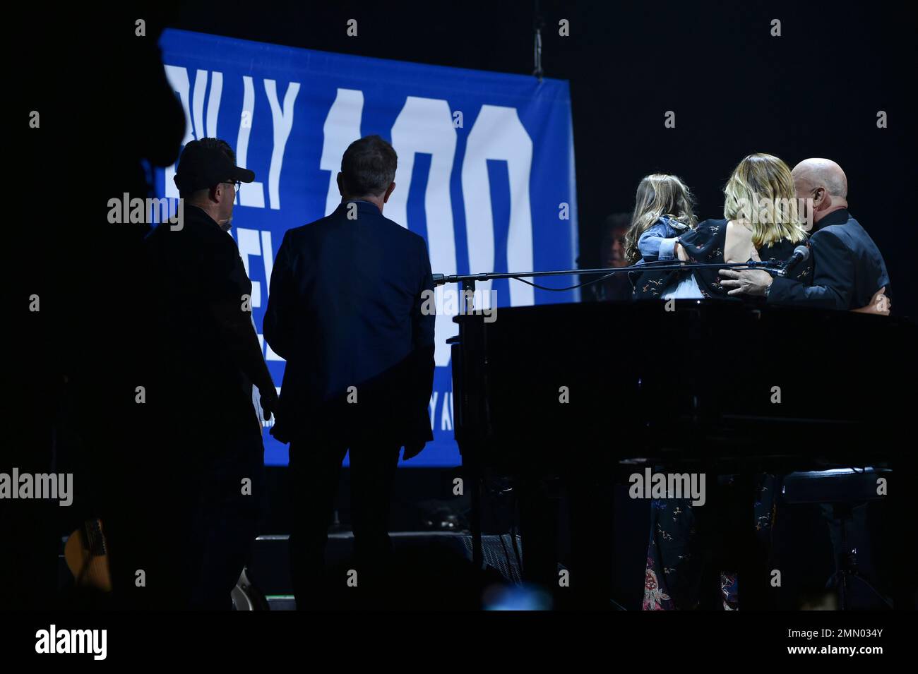 Musician Billy Joel, right, watches the 100th show banner being raised ...