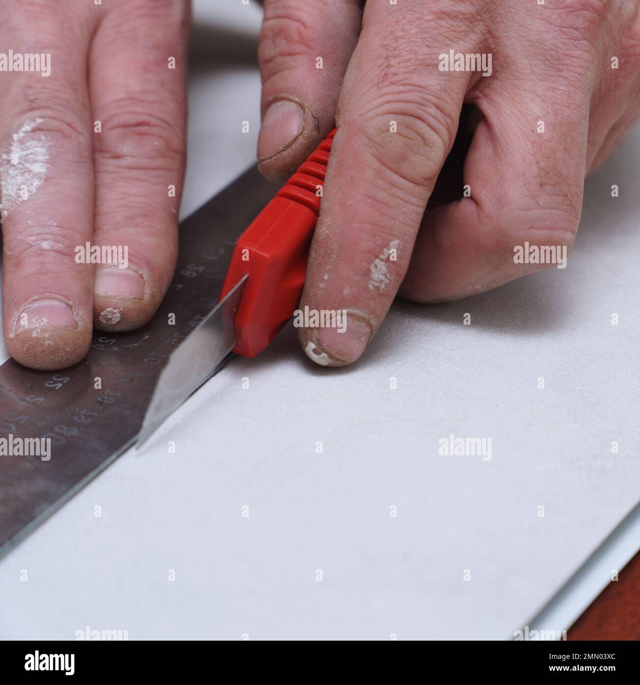 A man cuts a plastic pvc panel with a construction knife Stock Photo ...