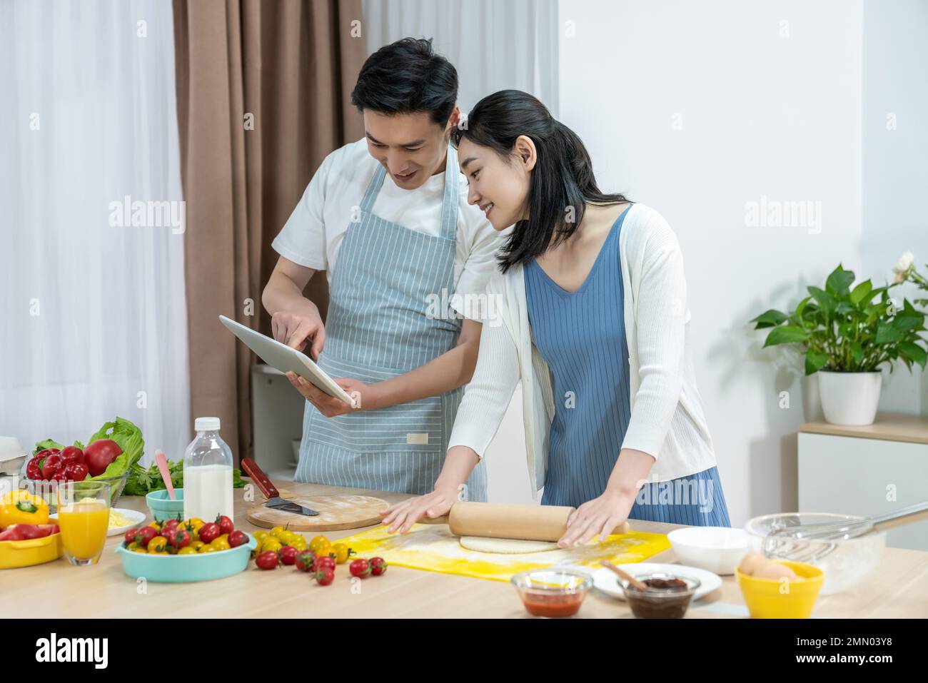 Happy young families making refreshments Stock Photo - Alamy