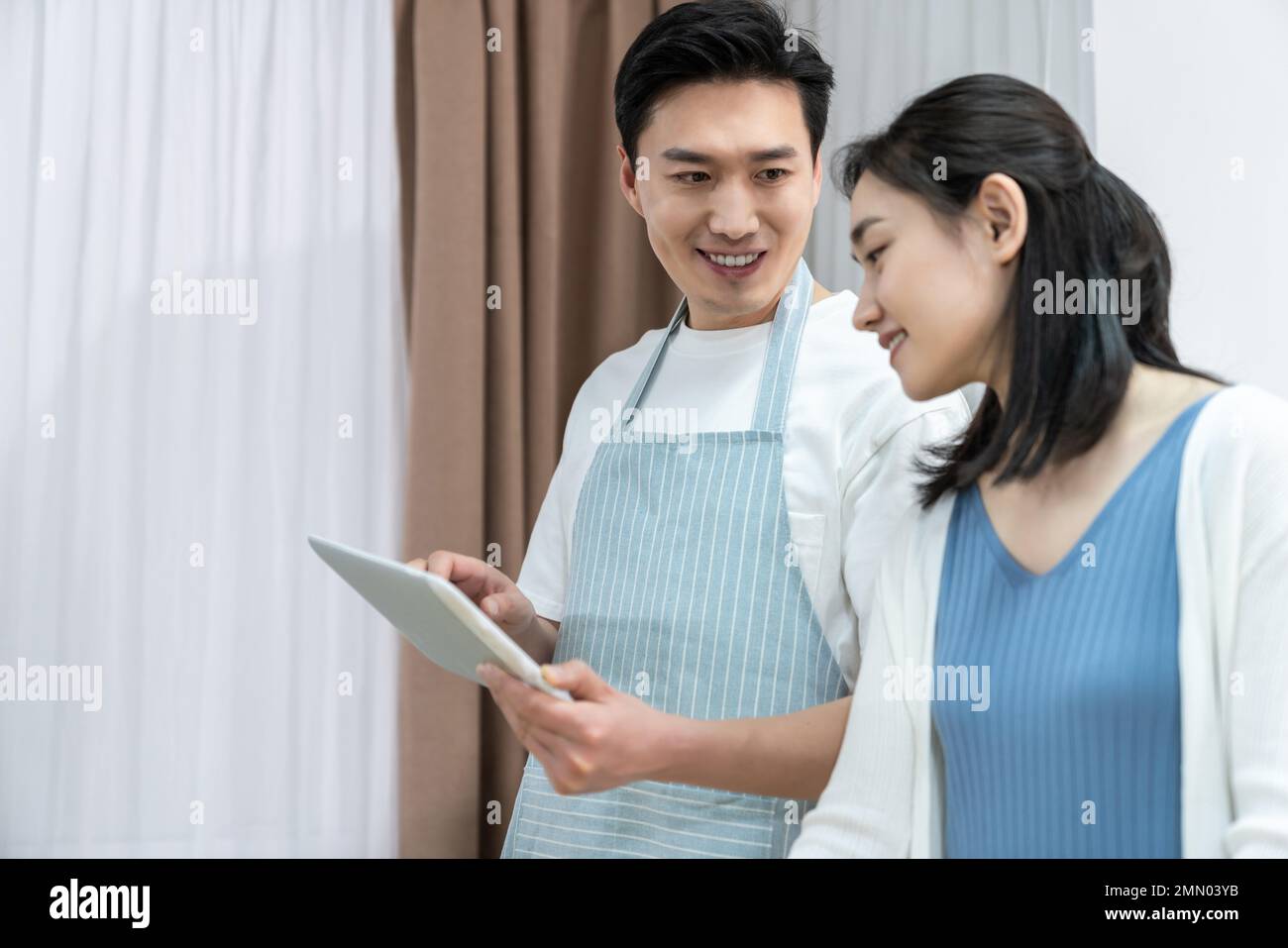 Happy young families making refreshments tablets Stock Photo - Alamy