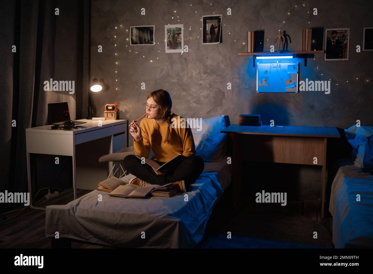 Serious female college student studying in dormitory preparing for exam ...