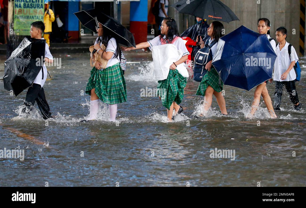 Students wade through floodwaters following overnight monsoon rains ...