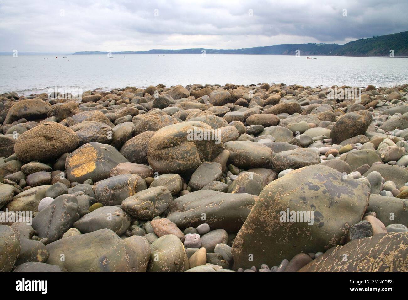 rounded rocks by the action of the sea and waves at Clovelly village in ...
