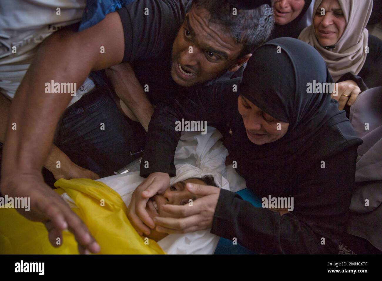 Relatives of 15-year-old Othman Hilles, mourn over his body during his ...