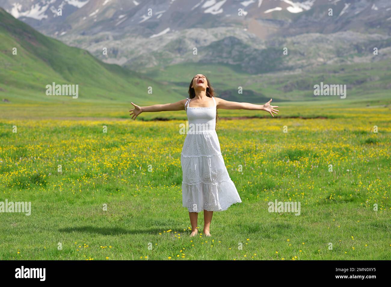 Front view portrait of a happy woman screaming outstretching arms in ...
