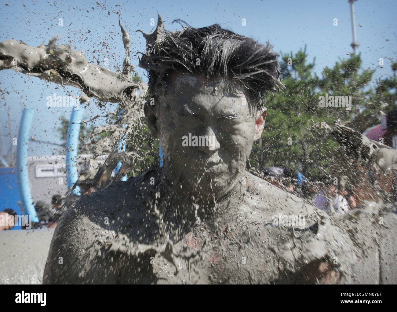 A man's face is hit by mud water during the Boryeong Mud Festival at ...