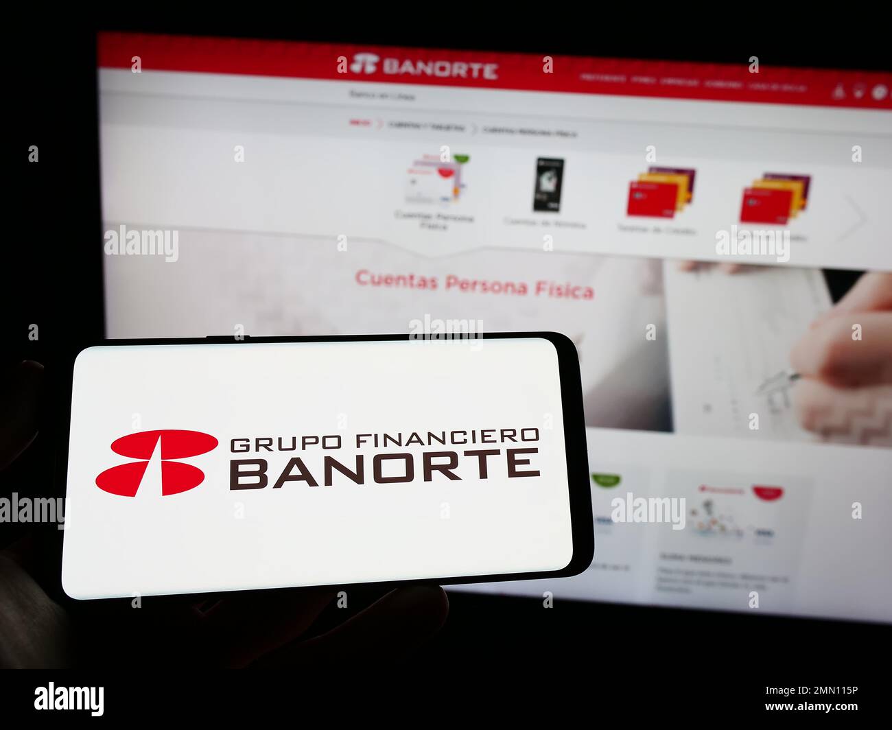 Person holding mobile phone with logo of Mexican banking company Grupo ...