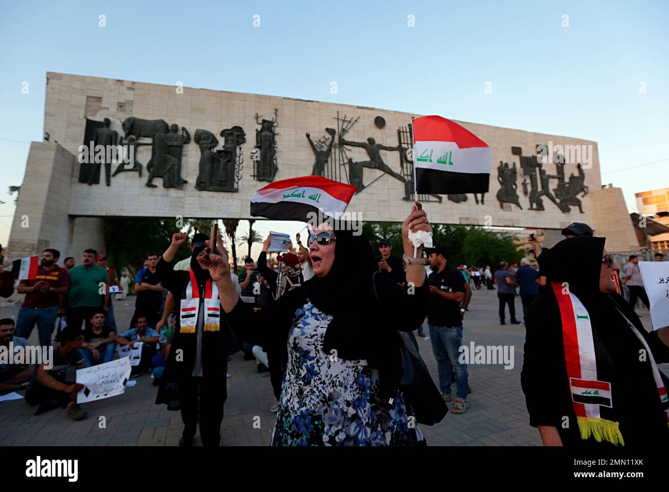 Protesters chant slogans demanding services as they wave national flags ...