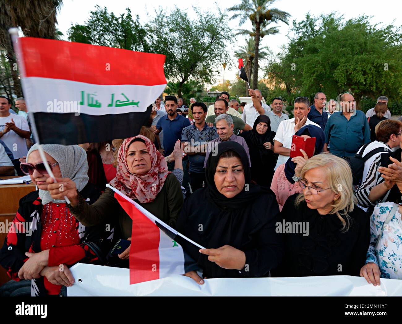 Protesters chant slogans demanding services as they wave national flags ...