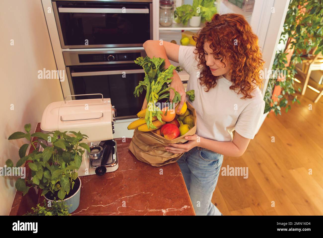 Ginger girl unpacking food in the kitchen Stock Photo - Alamy
