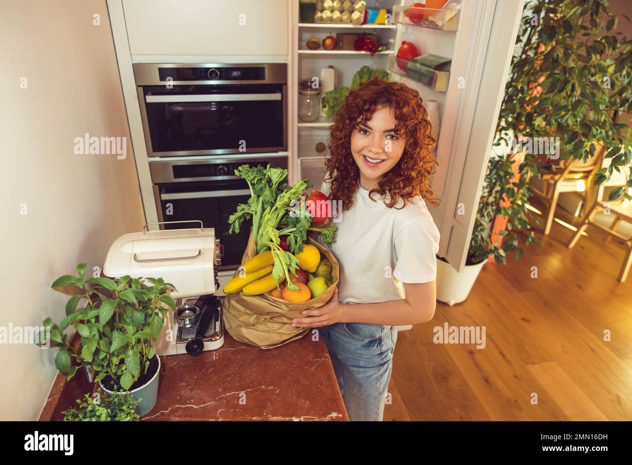Ginger girl unpacking food in the kitchen Stock Photo - Alamy