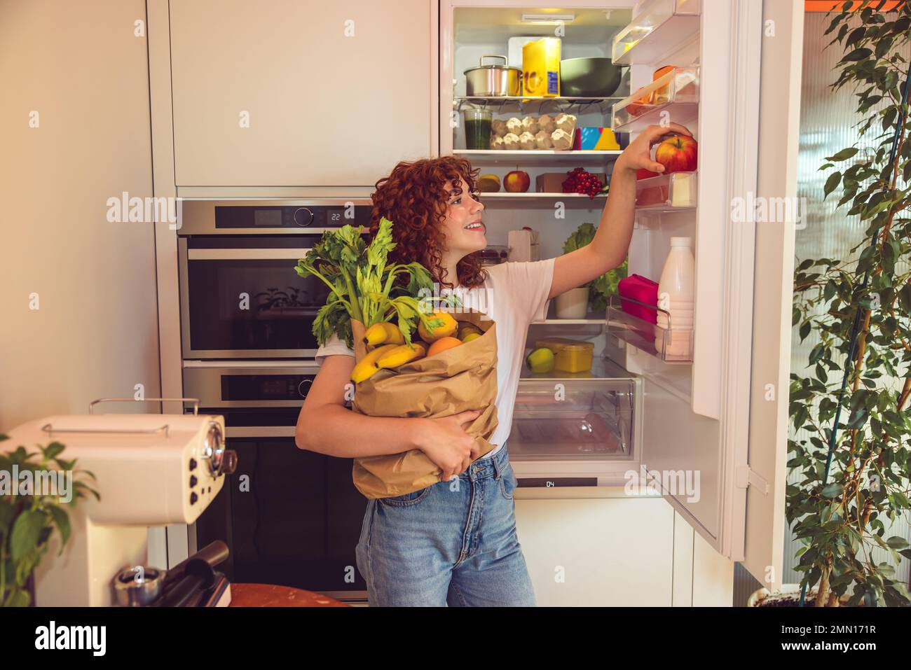 Ginger girl unpacking food in the kitchen Stock Photo - Alamy