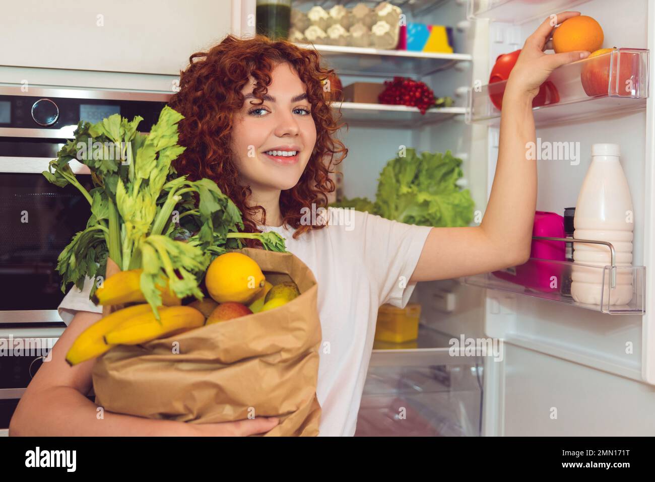 Ginger girl unpacking food in the kitchen Stock Photo - Alamy